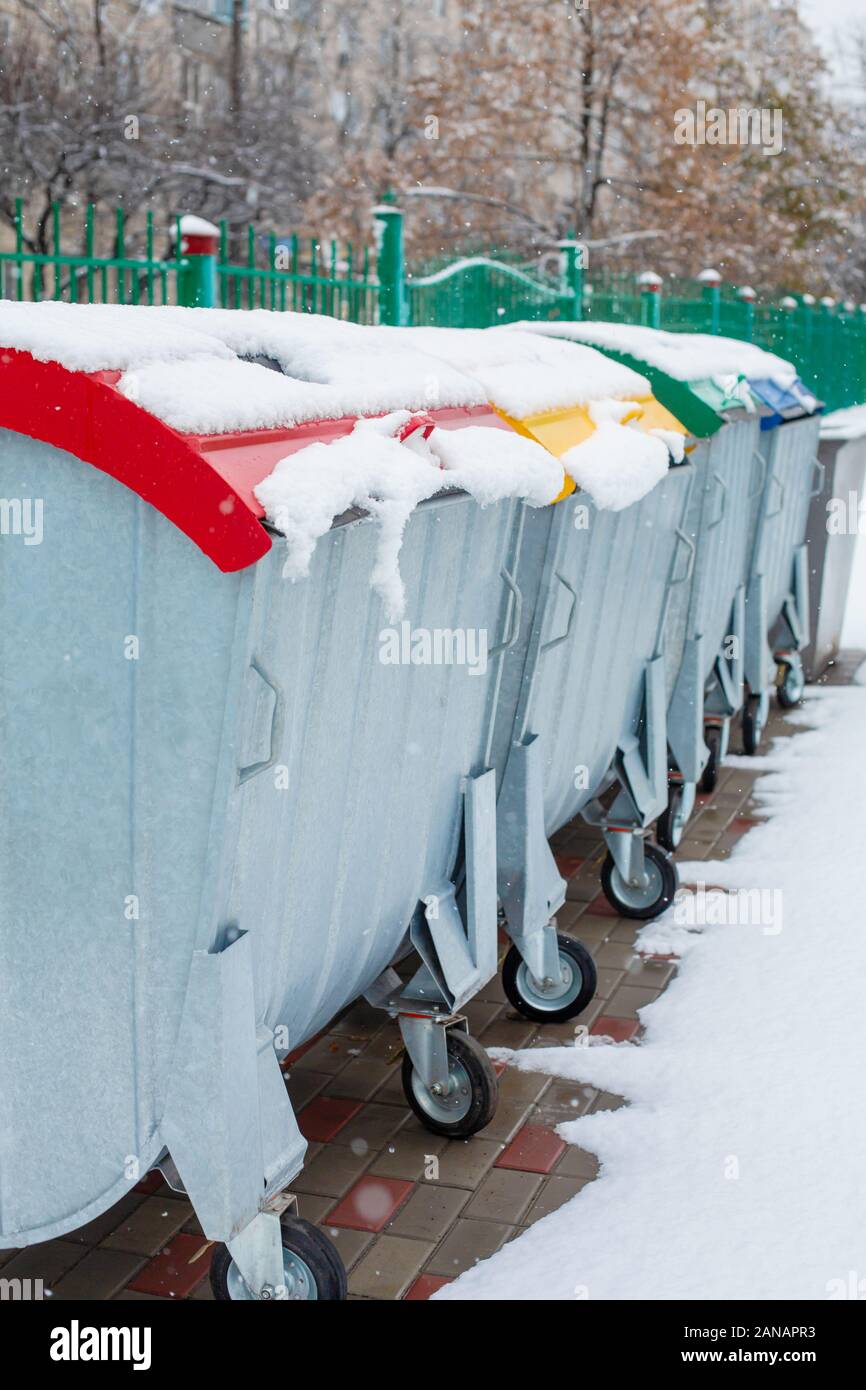 Trash bins for sorting garbage are standing on the street covered with ...