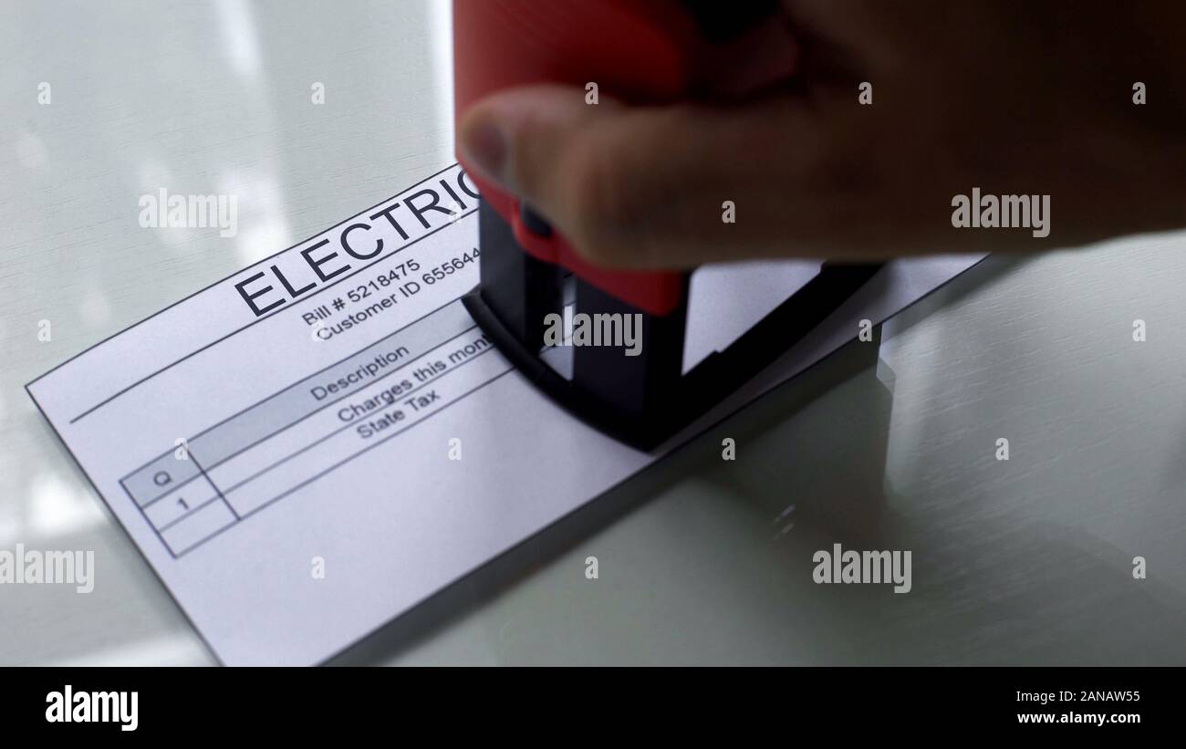Electricity bill, hand stamping seal on document, payment for services ...