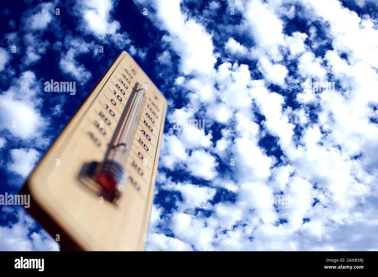 Thermometer on the blue sky and clouds background. Weather forecast and ...