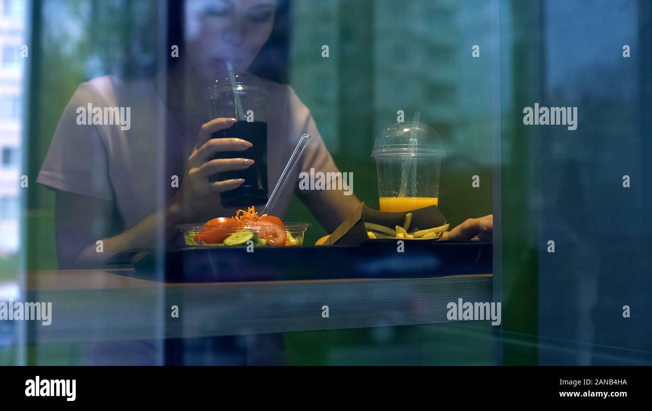 Pretty female drinking carbonated water from plastic glass, canteen ...