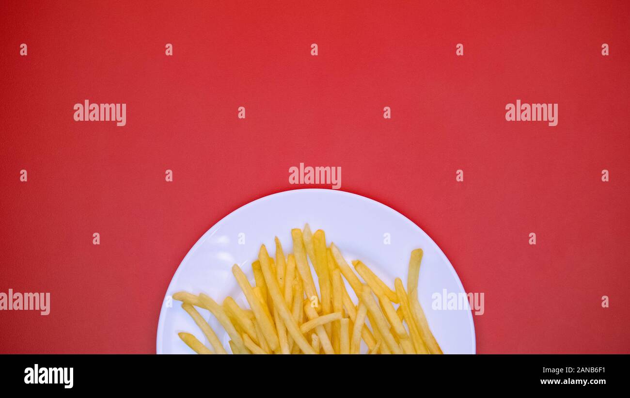 White plate with french fries on red background, fast food dinner ...