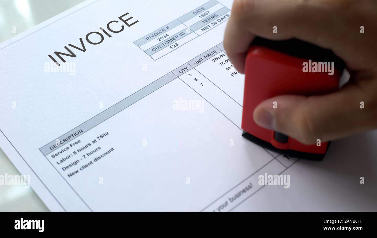 Invoice, worker hand stamping rectangular seal on commercial document ...
