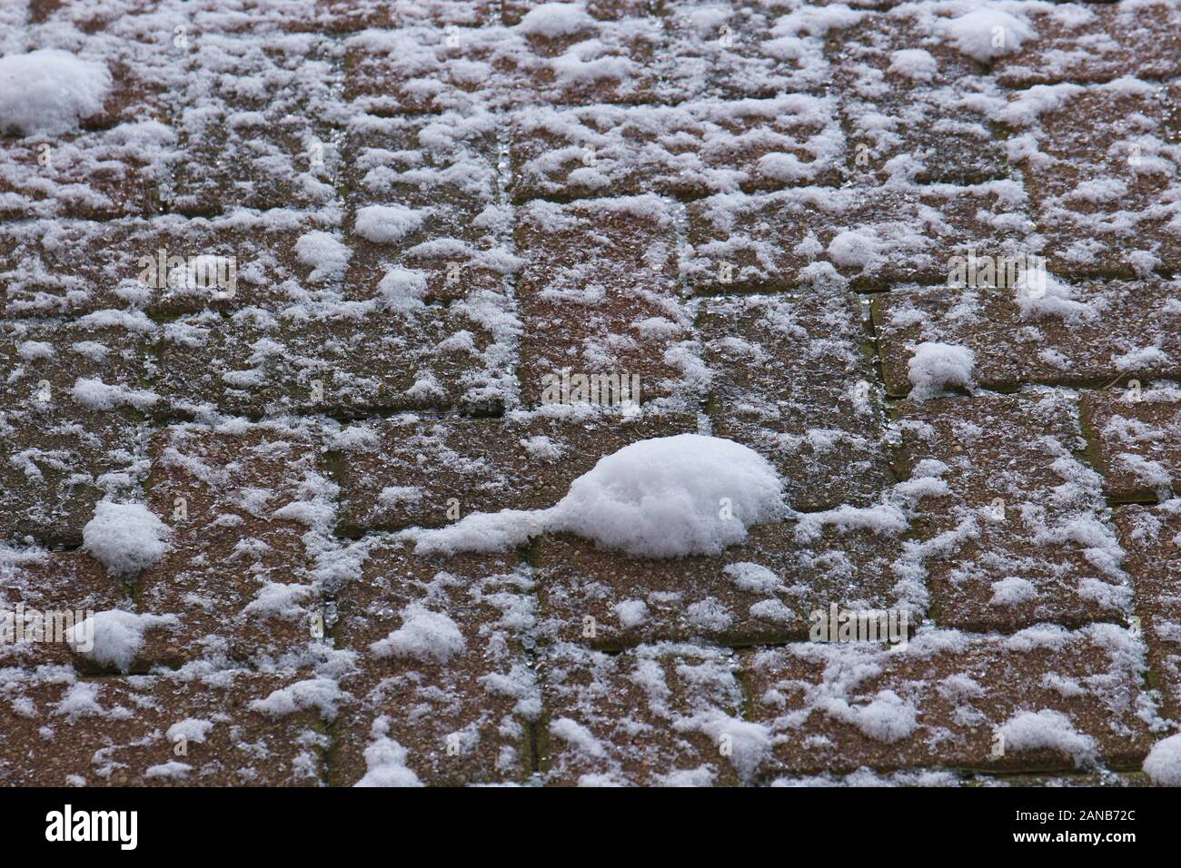 Small clumps of ice and snow covering a brick patio Stock Photo - Alamy