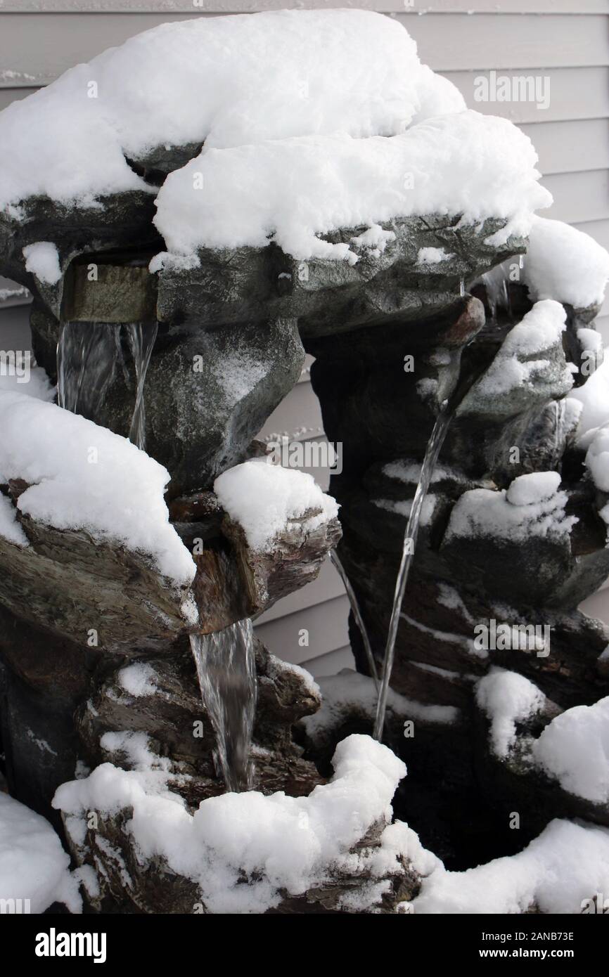 Snow piled up on an outdoor waterfall feature after an early snowfall ...