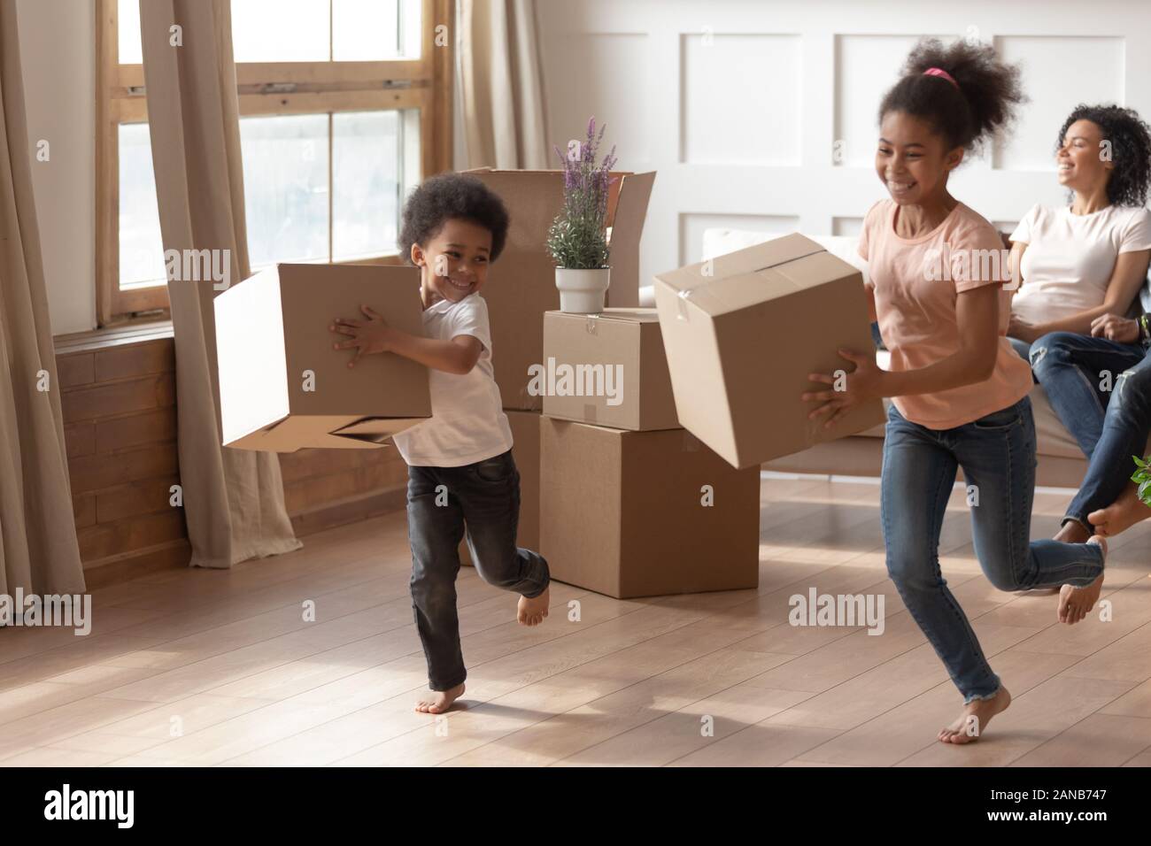 Overjoyed black kids running, playing with carton boxes Stock Photo - Alamy