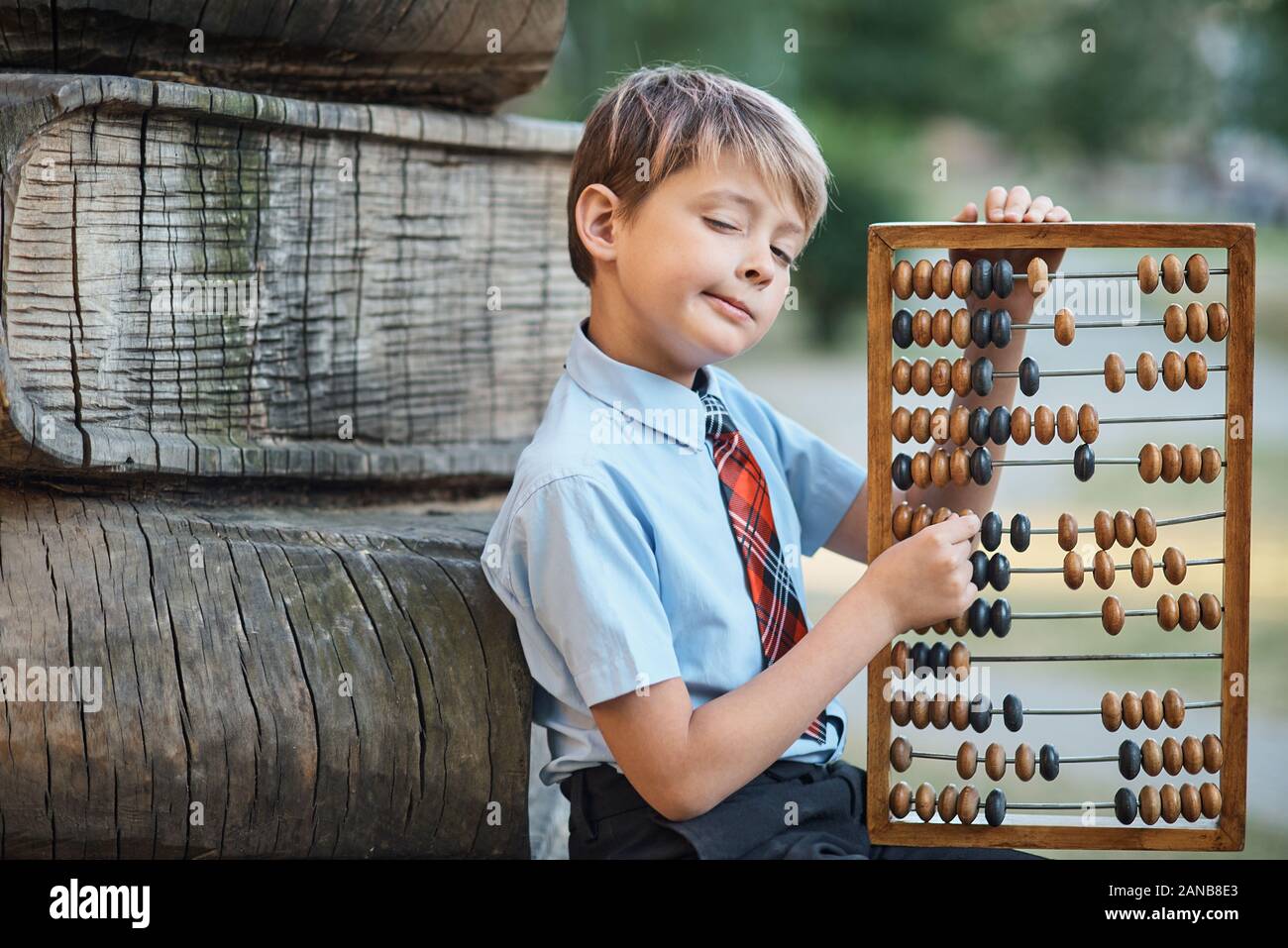 Boy with large abacus. Thoughtful schoolboy using a maths abacus ...