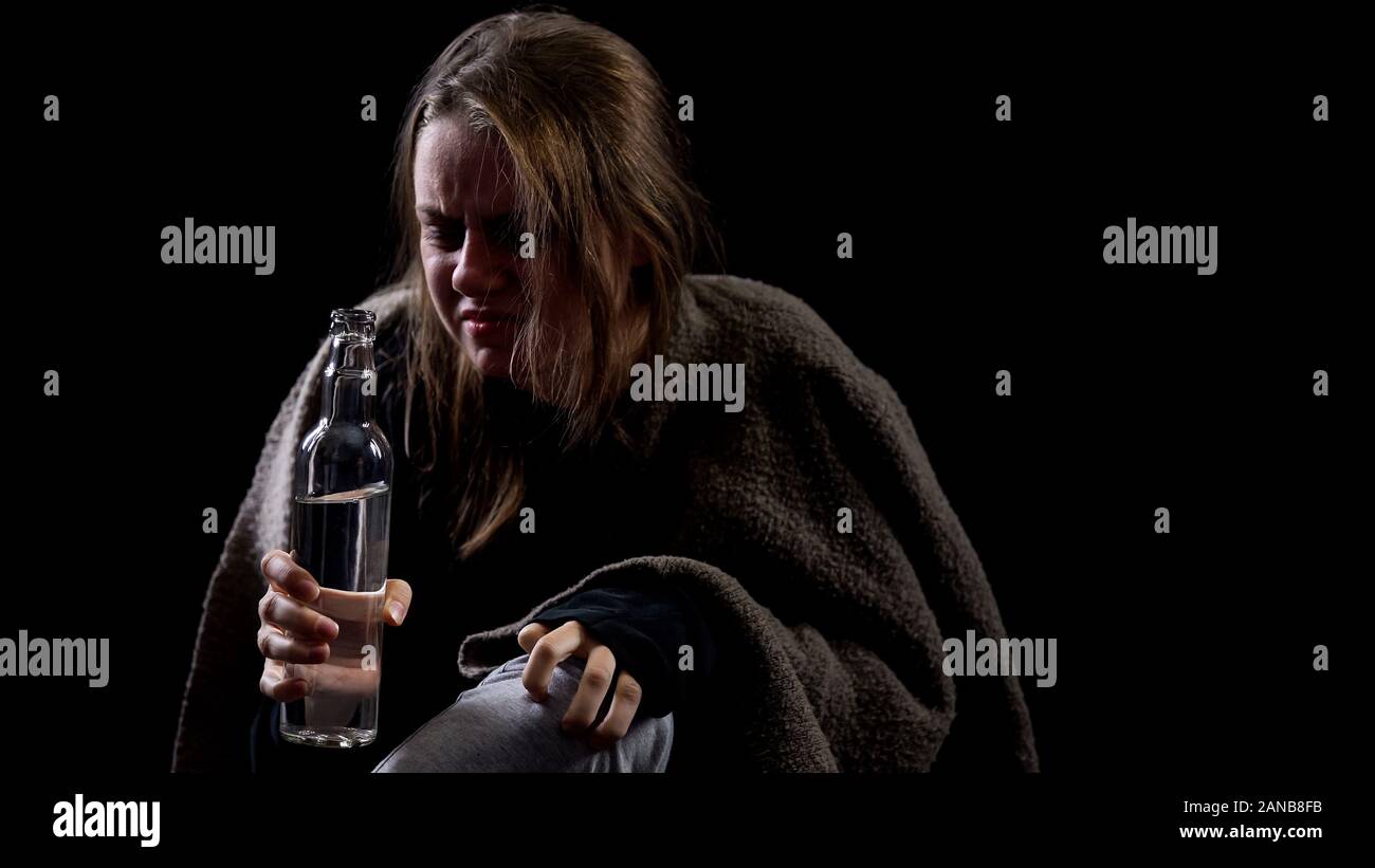 Alcoholic woman holding bottle of vodka with disgust, miserable life ...