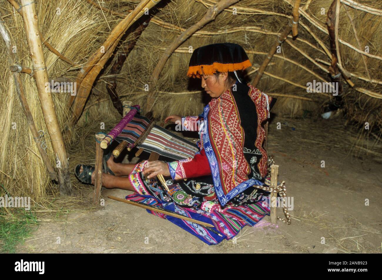 Woman in traditional Peruvian clothes makes yarn from Alpaca and Llama ...