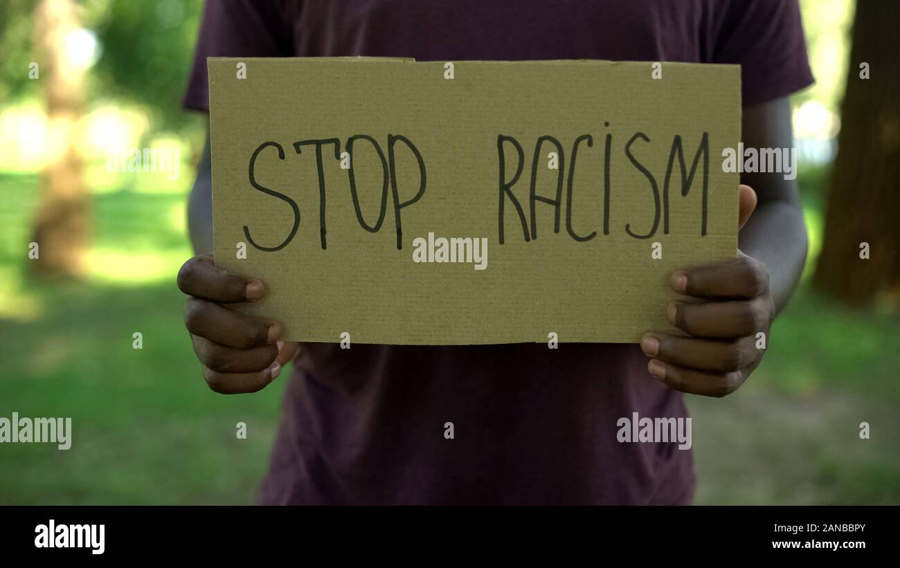 Afro-american male showing stop racism phrase cardboard, equal rights ...