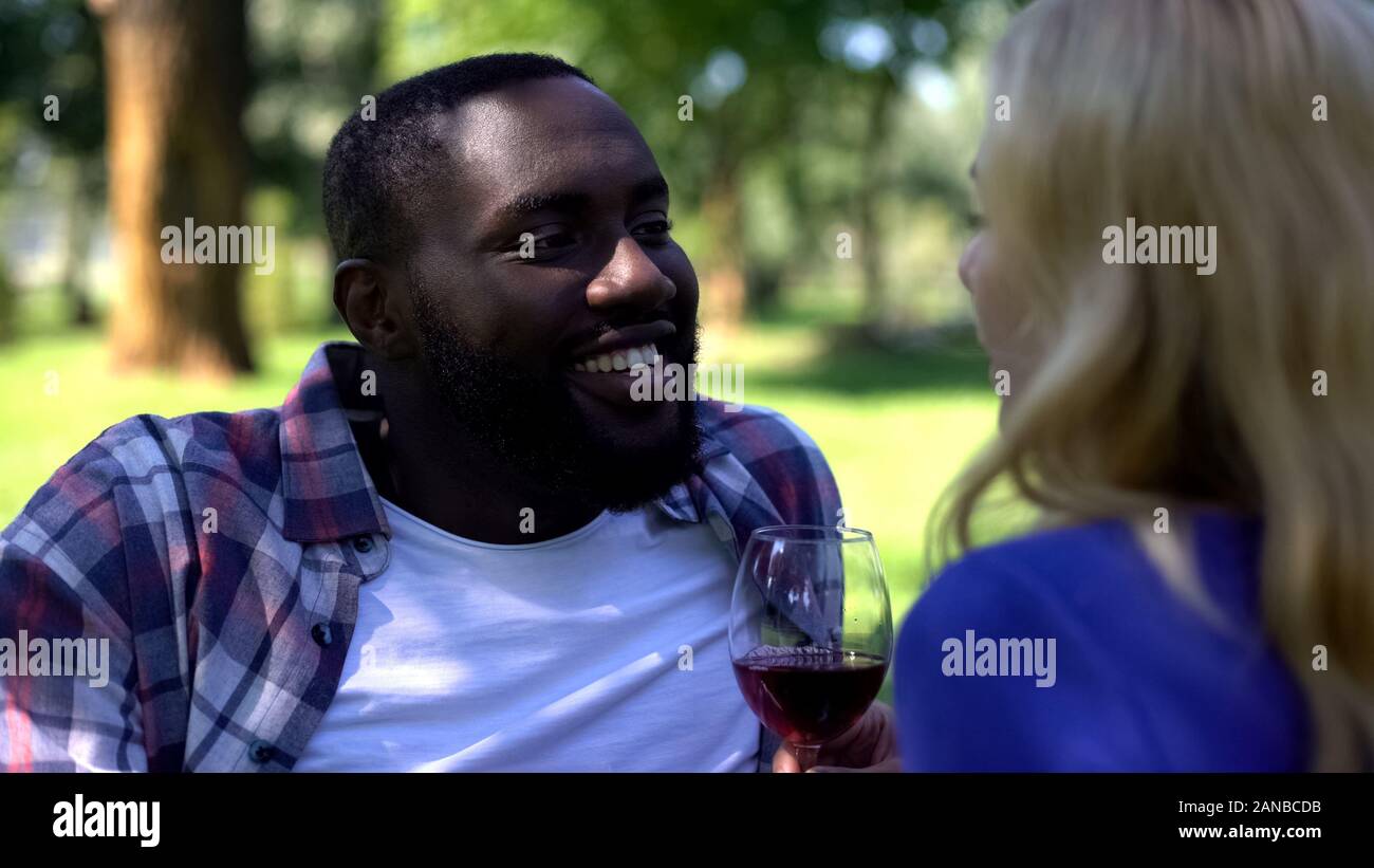 Happy couple drinking expensive old wine, enjoying aged alcohol in park ...