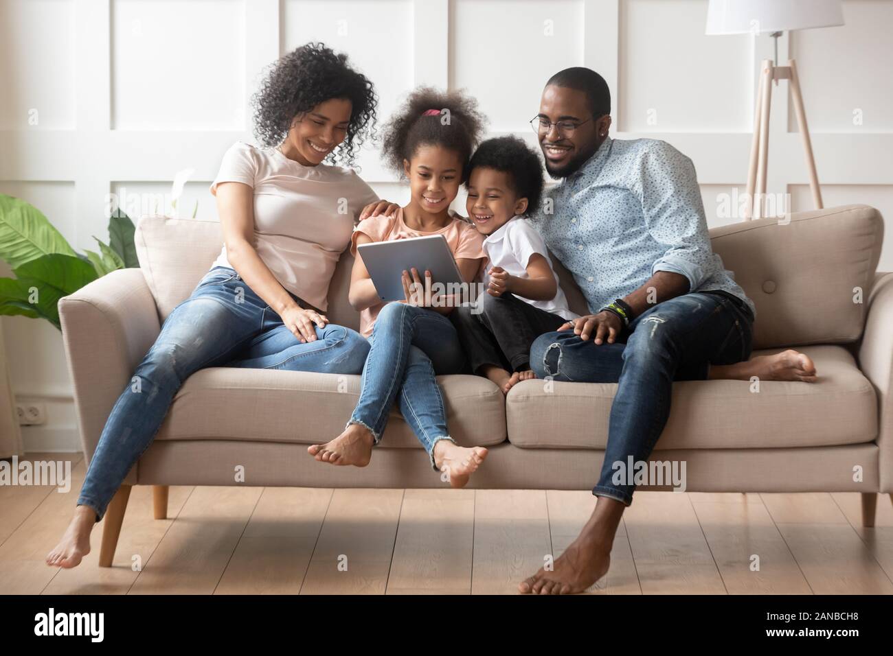 Happy african american family using tablet together Stock Photo - Alamy