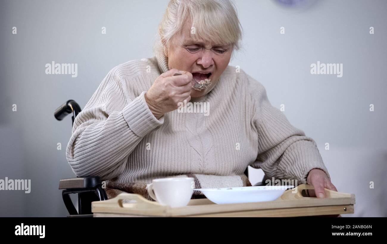 Handicapped lady reluctantly eating dinner in medical center ...