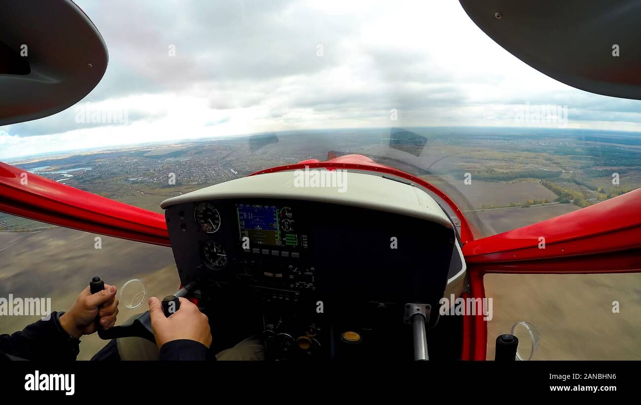 Male sitting in cockpit of jet plane flying over field, extreme sport ...