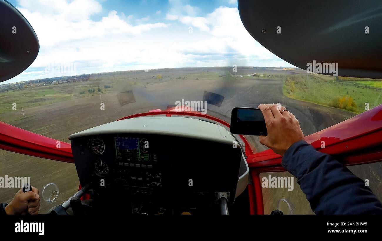 Male filming sports plane landing on smartphone pov, extreme hobby ...