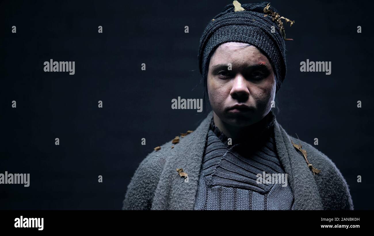 Bum looking in camera on dark background, social problem, poverty ...