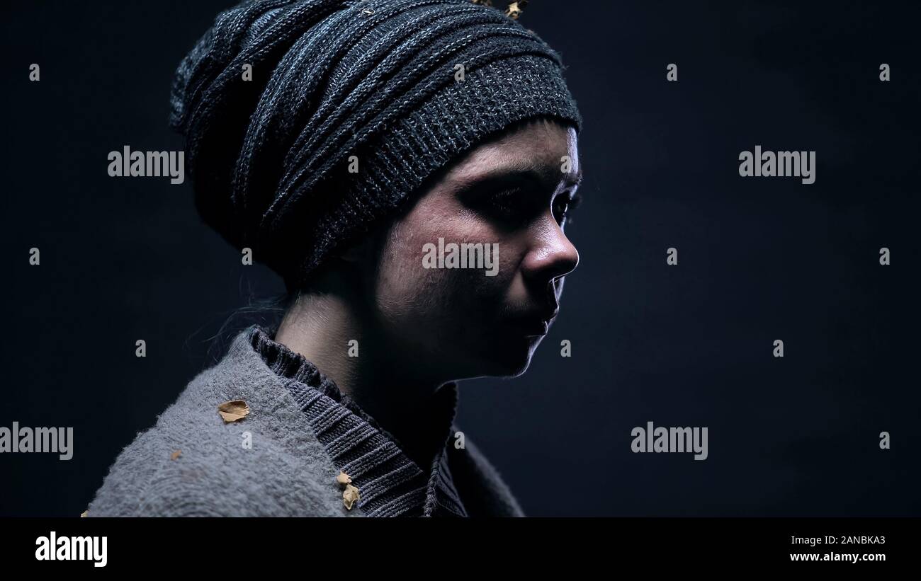 Desperate homeless female on dark background closeup, assault in family ...