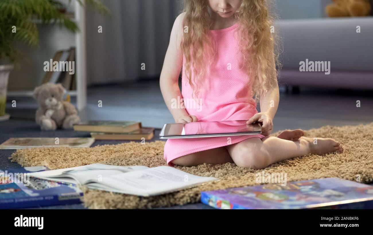 Little girl playing interactive educational game on tablet, using ...