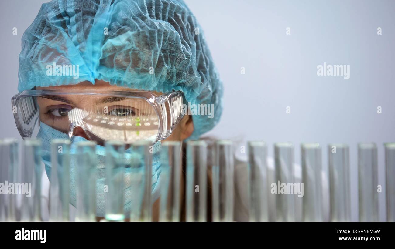 Medical scientist analyzing biochemical reaction in tubes, laboratory ...