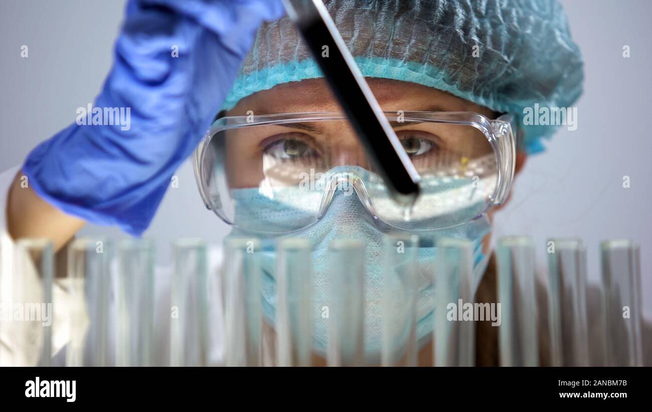 Chemical lab worker holding tube liquid, petrol quality improvement ...