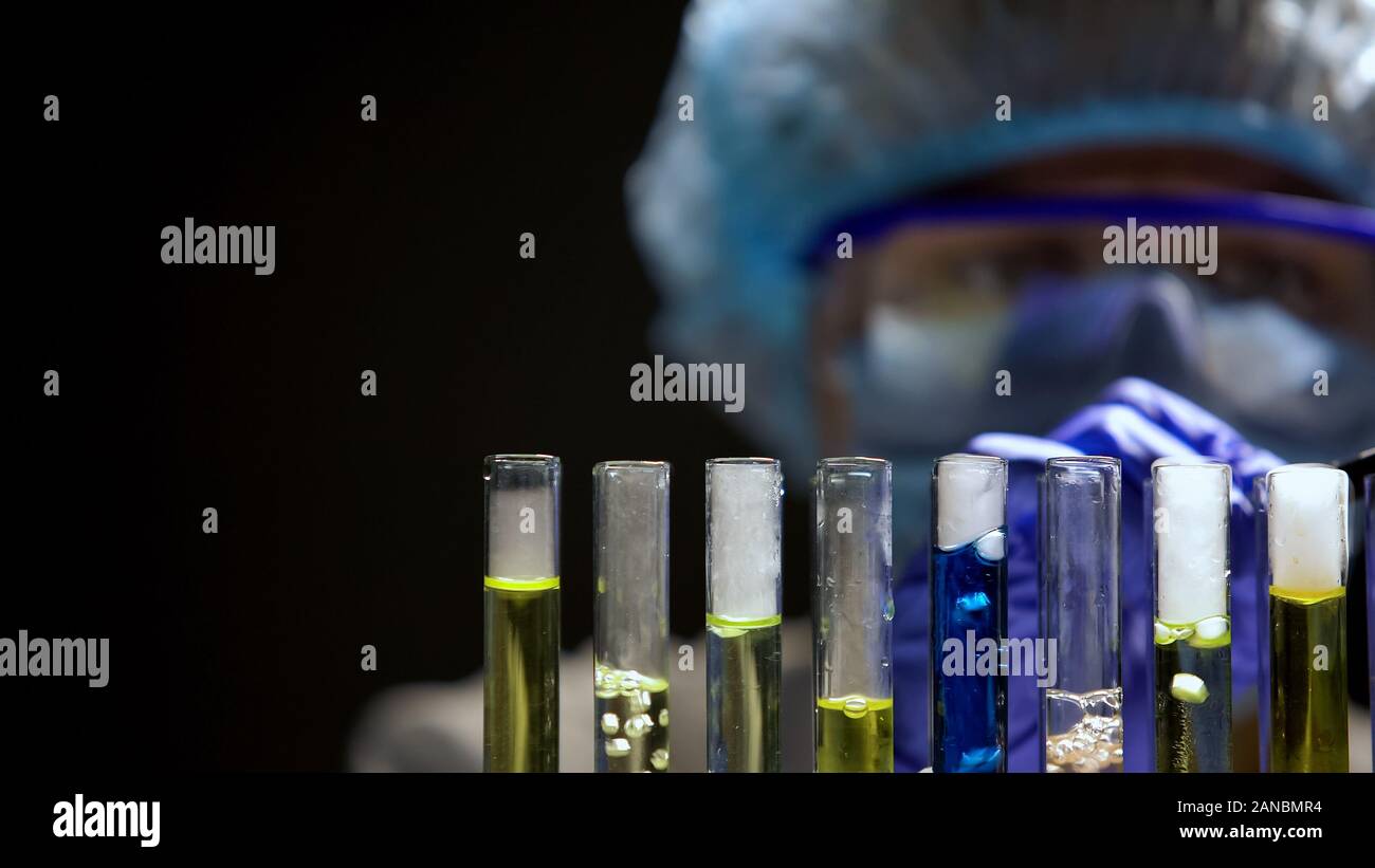 Chemist checking reaction in test tubes, secret laboratory experiment ...