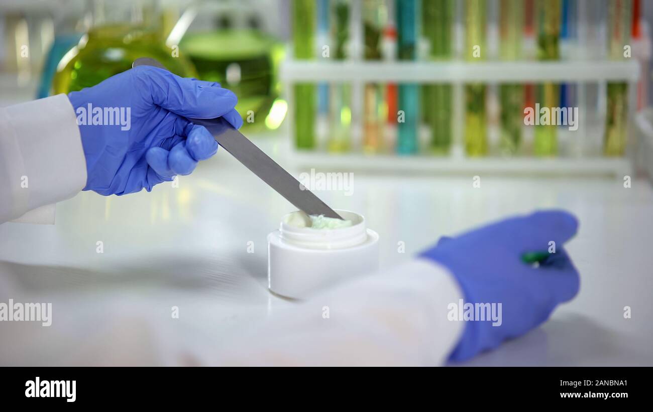 Chemist taking cream from tube, organic cosmetic production for ...