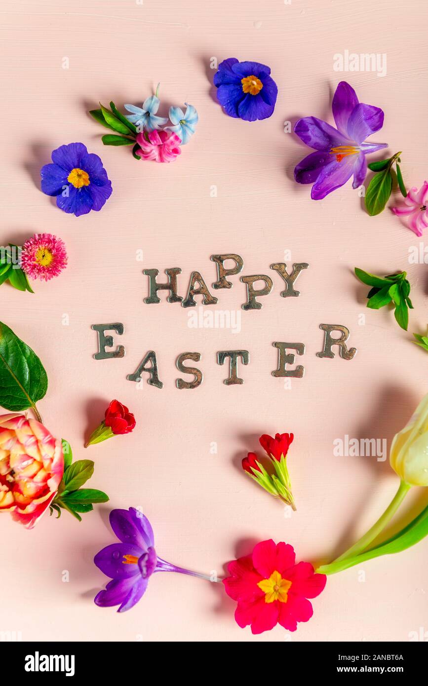 Happy Easter letters with different spring flowers around them, flat ...