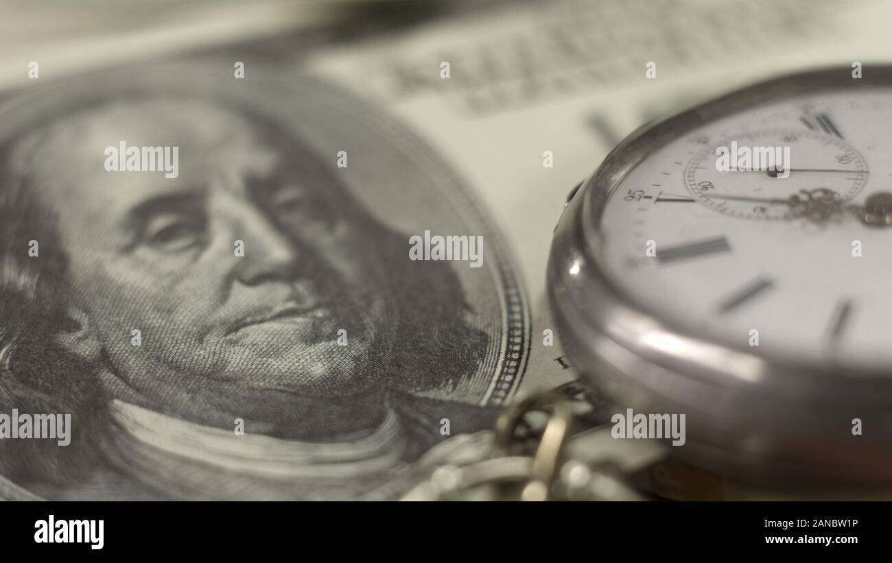 Ancient pocket watch lying on dollar bill, time is money, banking and ...