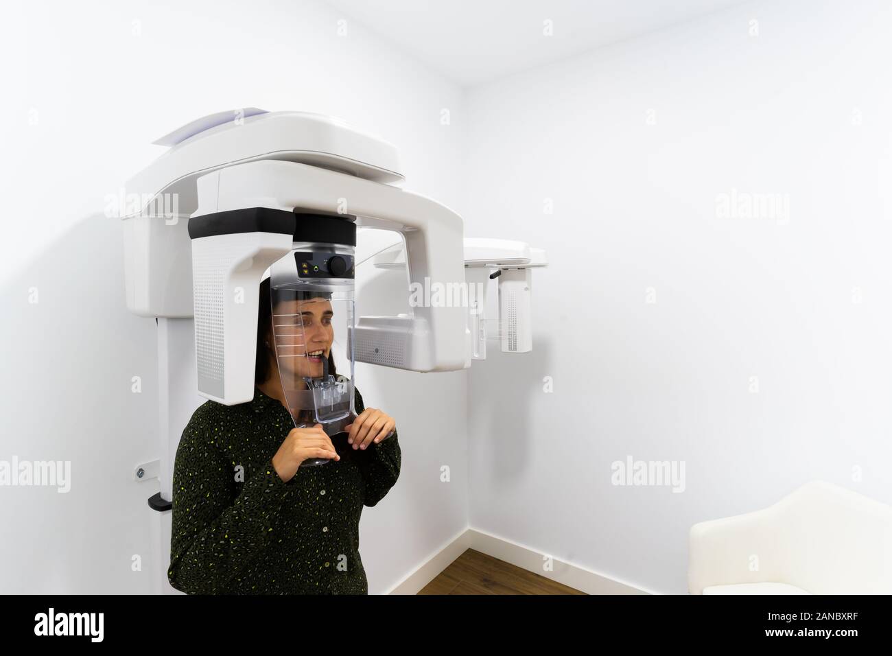 Young woman patient standing in x-ray machine. Panoramic radiography ...