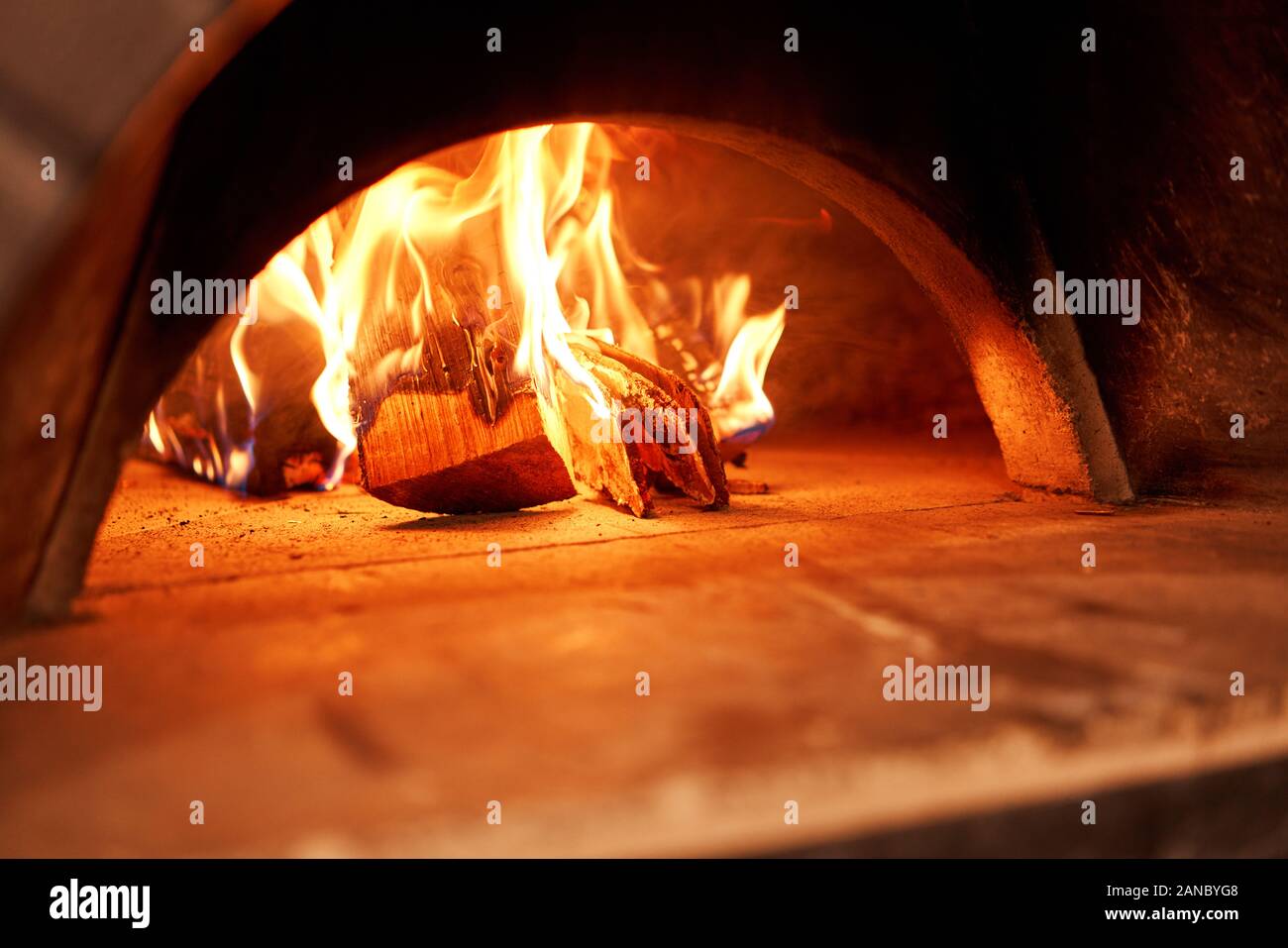 Firewood is burning, the stove is being heated. Red hot coal. Traditional wood oven in Naples ...