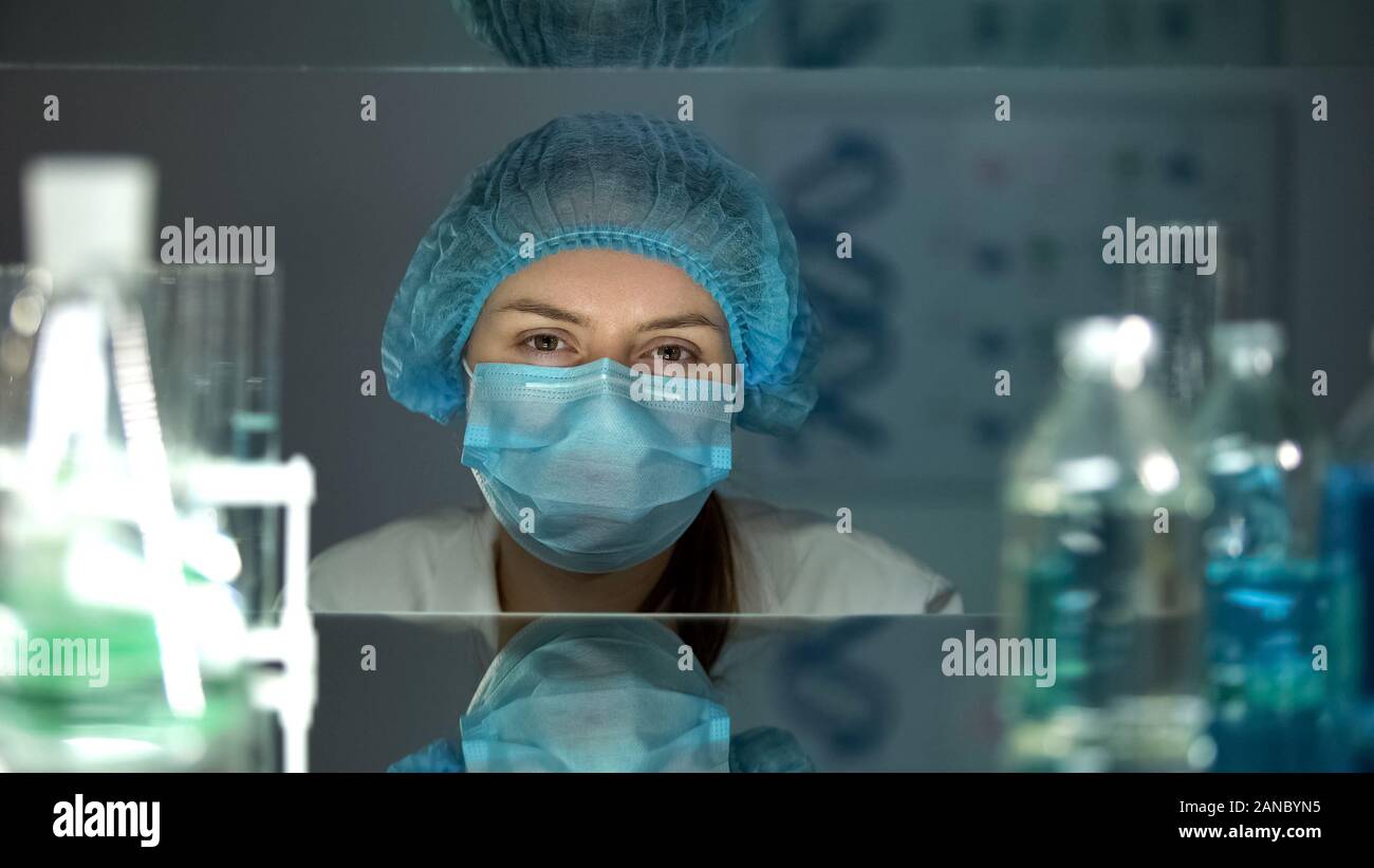 Female chemical in protective uniform looking at camera, working in ...
