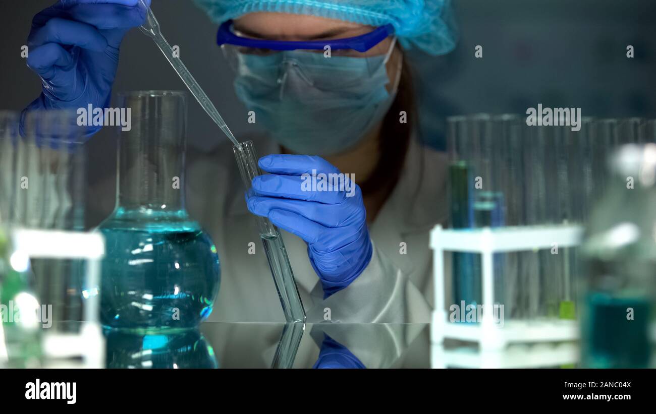 Researcher dripping liquid in test tube, with water sample, checking PH ...