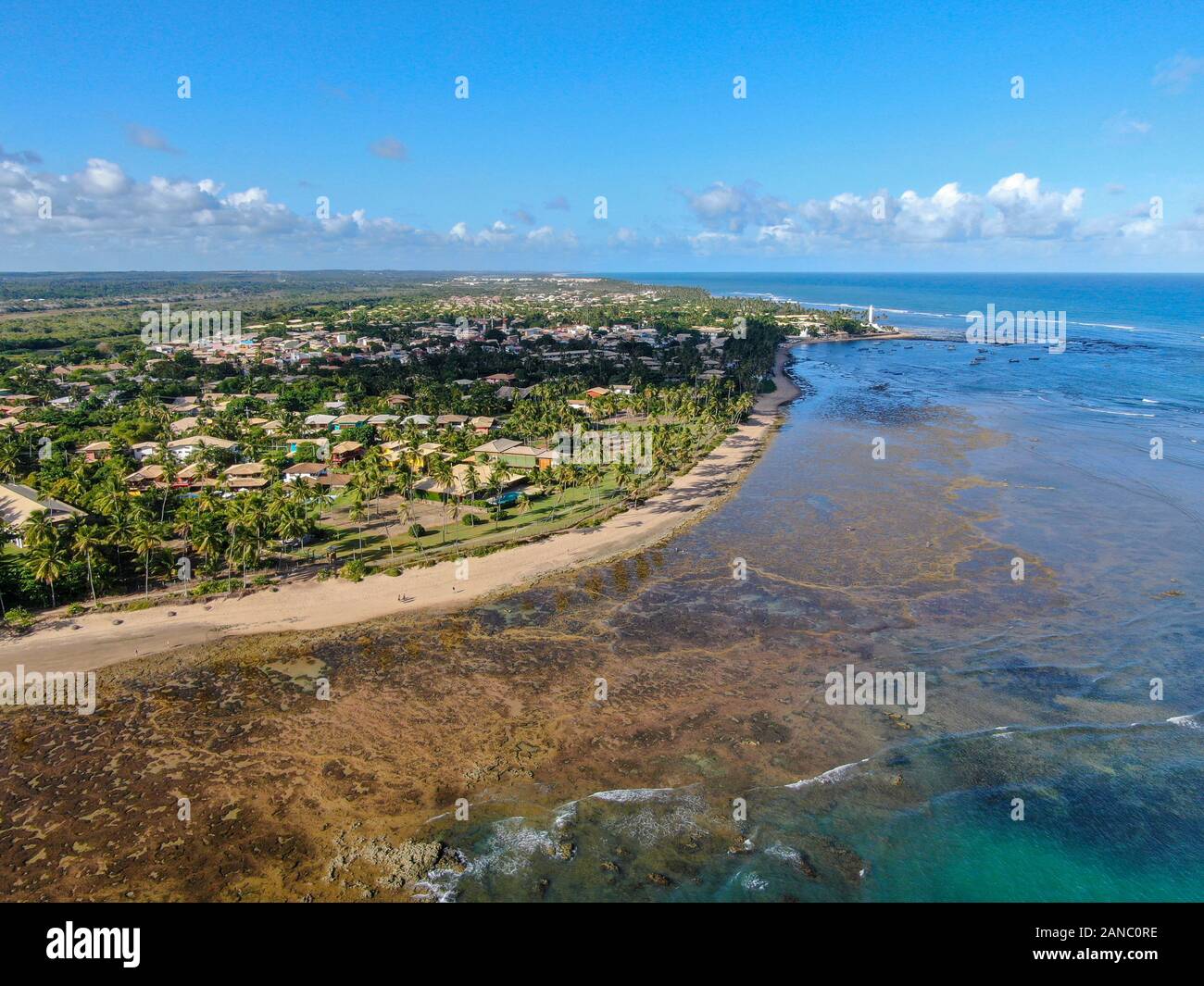 Aerial view of Praia Do Forte coastline village with beach and blue ...