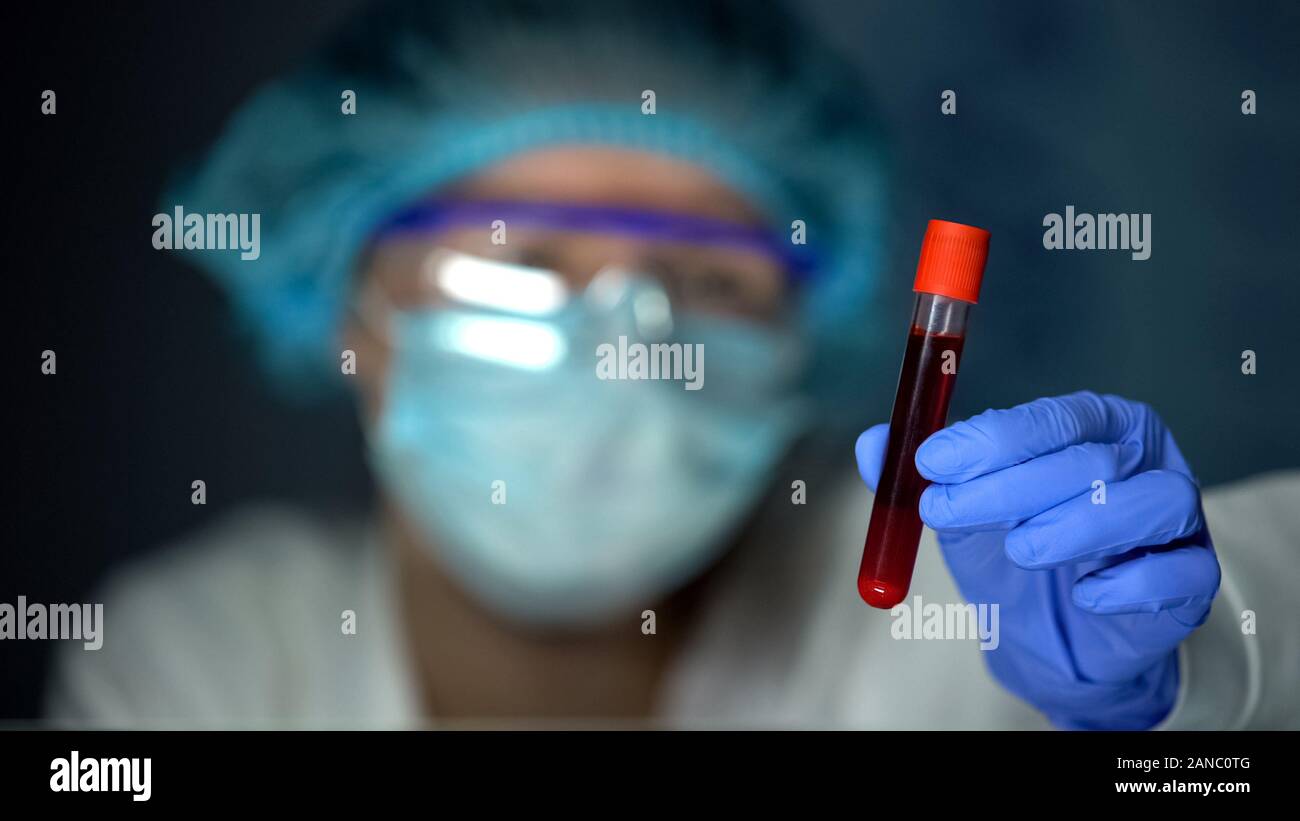 Epidemiologist checking blood sample in tube, virus vaccine development ...