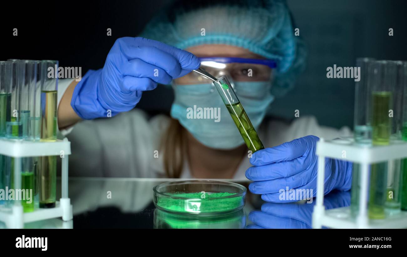 Lab assistant adding green liquid hi-res stock photography and images ...