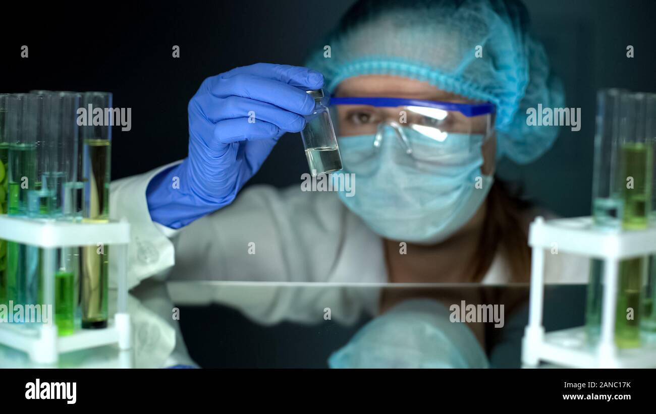 Scientist holding bottle with transparent injection liquid, antibiotic ...