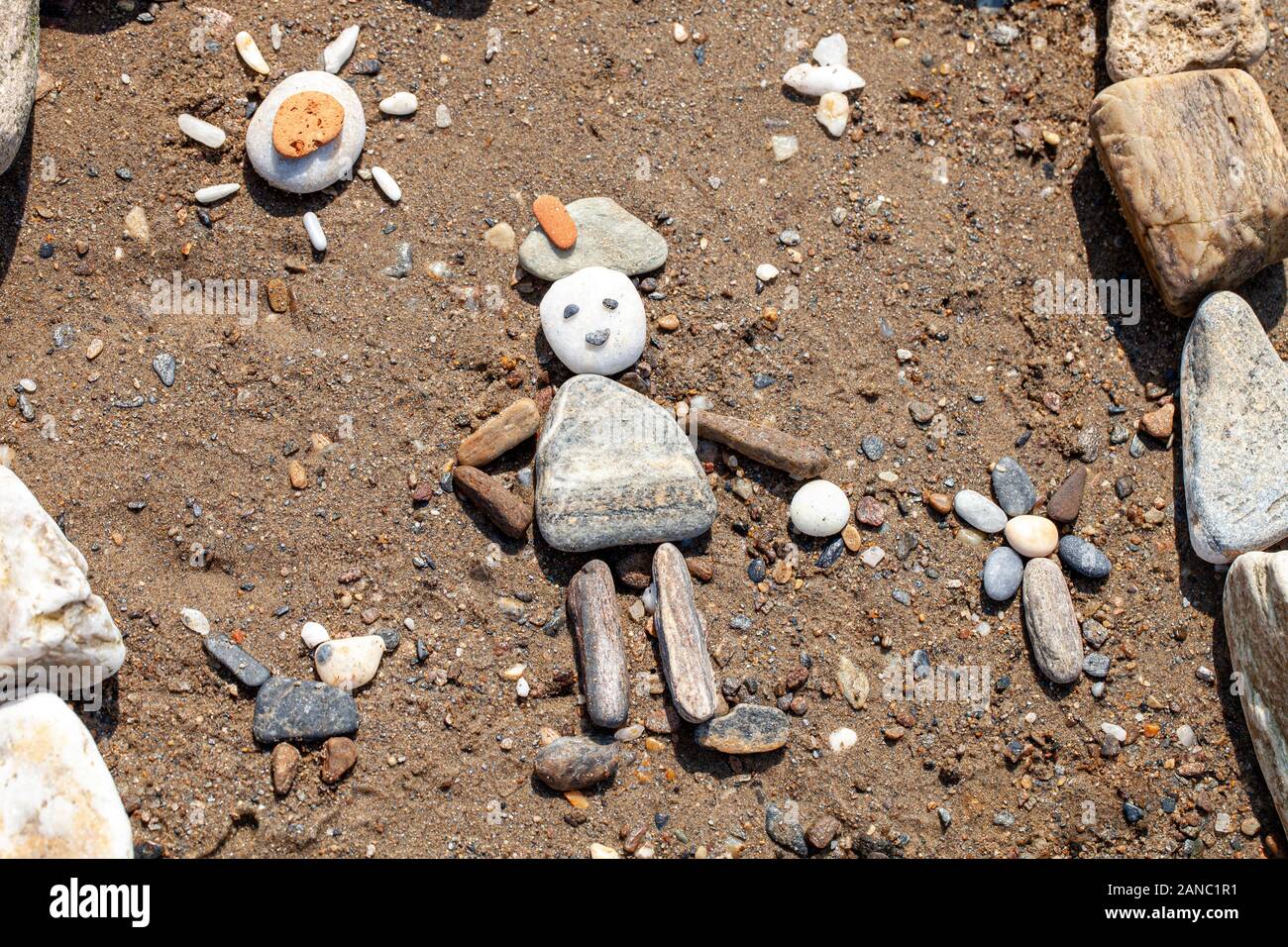 Touching рicture of sea pebbles on the shore. Child plays ball. An ...