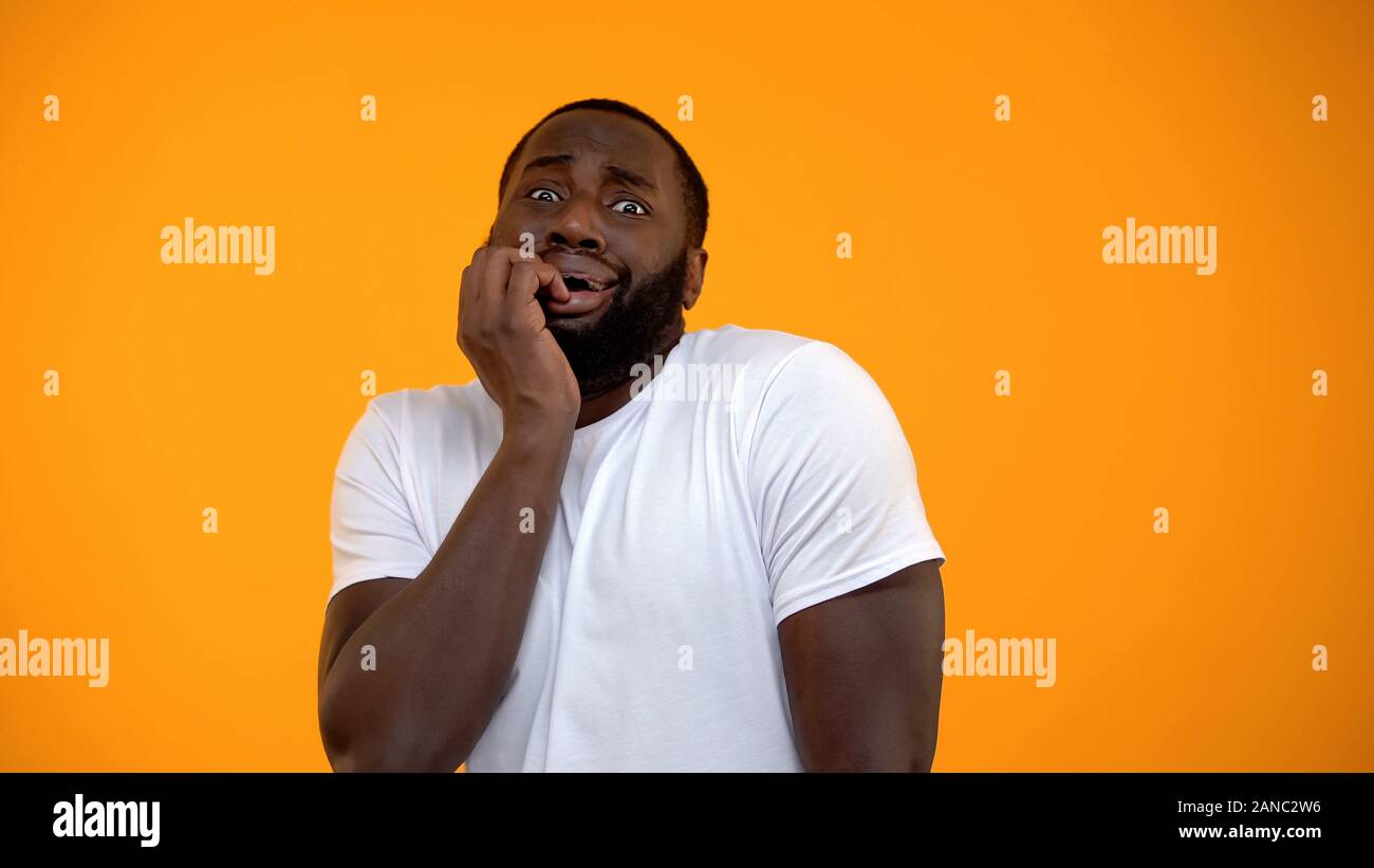 Funny Afro-American man feeling fear isolated on yellow background ...