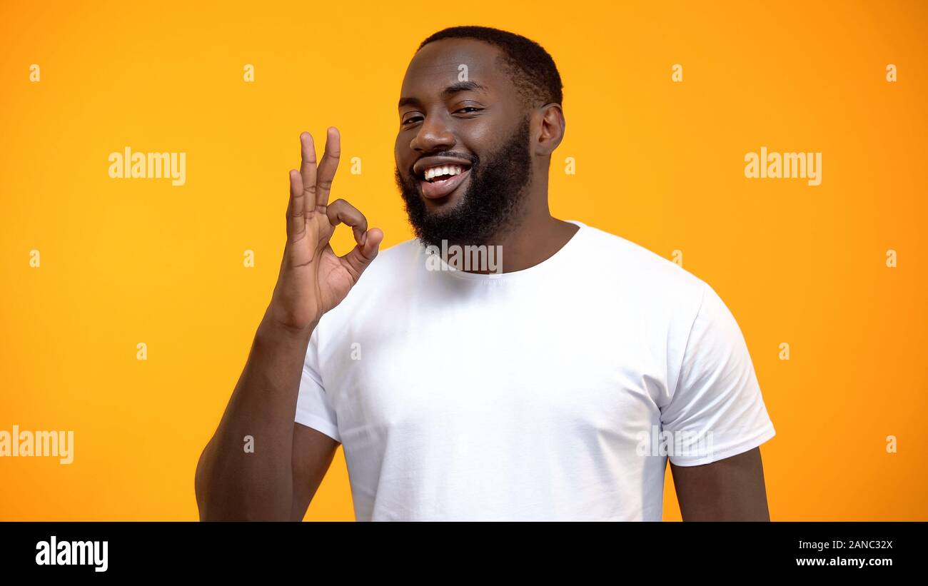 Handsome Afro-American man showing OK sign, customer review, friendly ...