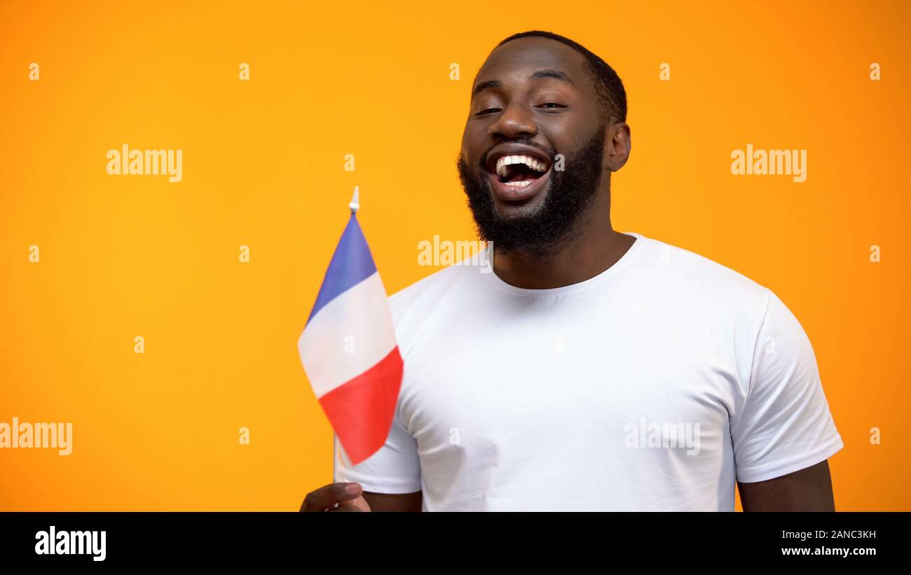 Afro-American man holding French flag on national holiday celebration ...