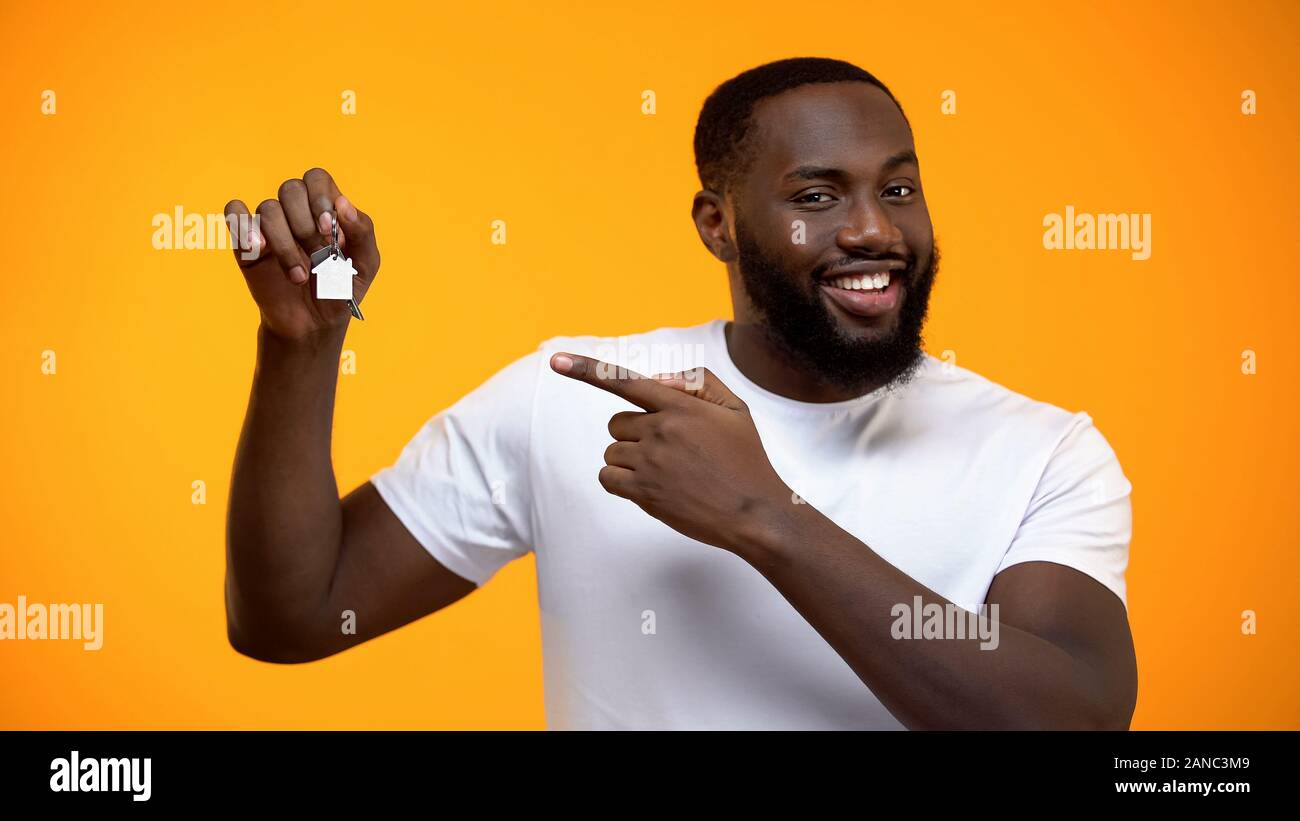 Smiling African-American man pointing finger into house keys, real ...