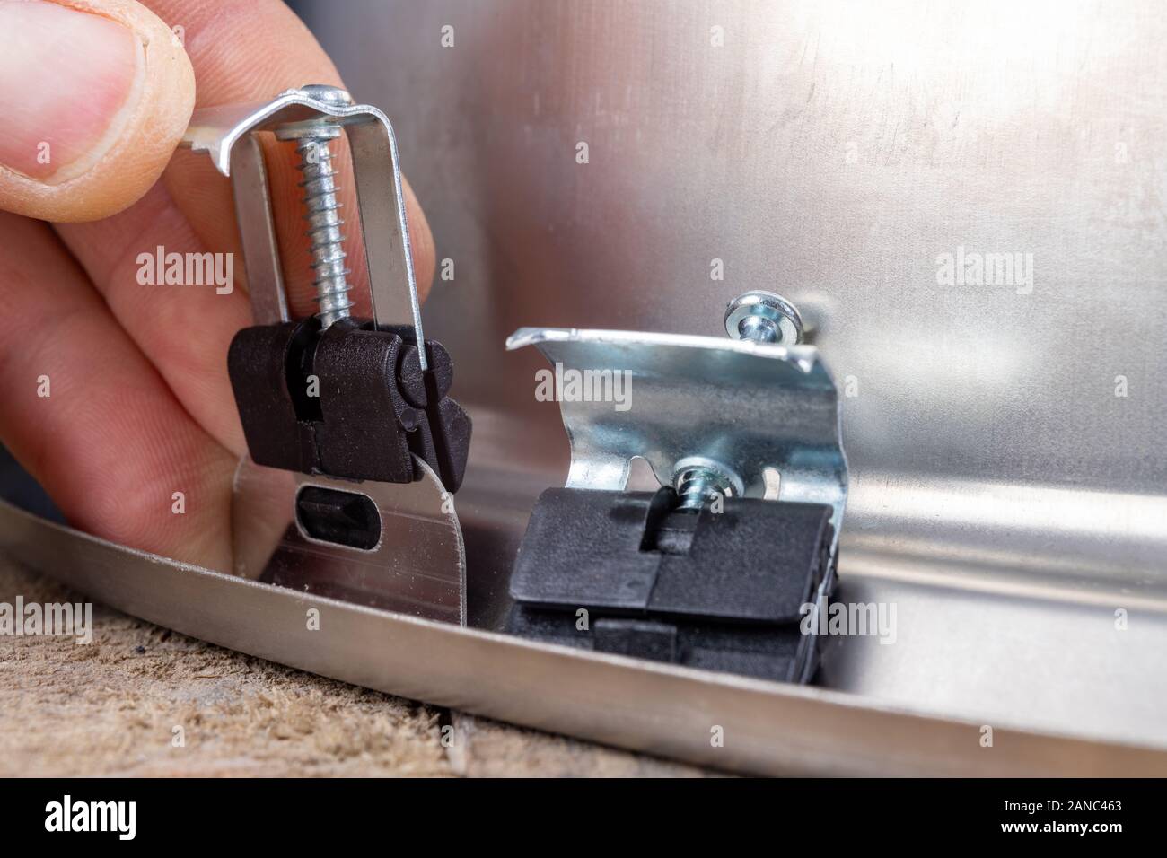 Hook for mounting a metal sink in a kitchen counter. Installation of ...