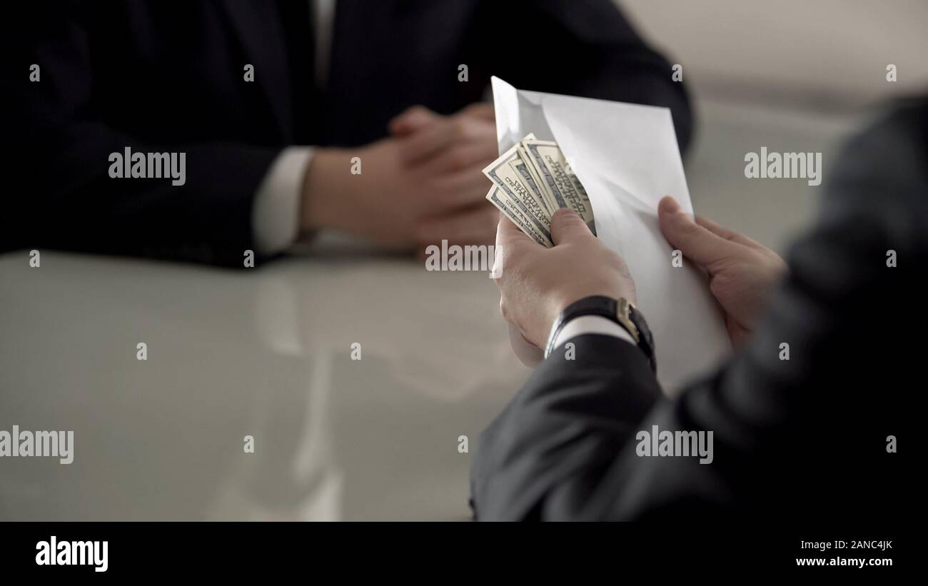 Businessman counting money in envelope, bribe to official, corruption ...