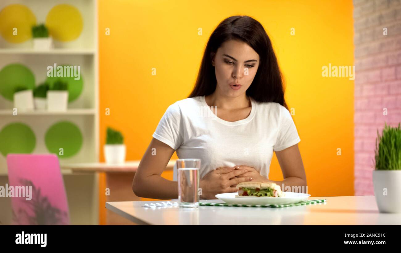Woman touching stomach after high-calorie meal, overeating problem ...