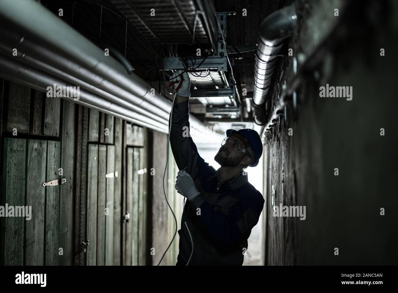 Silhouette Of A Male Electrician Installing Light At Basement Stock ...