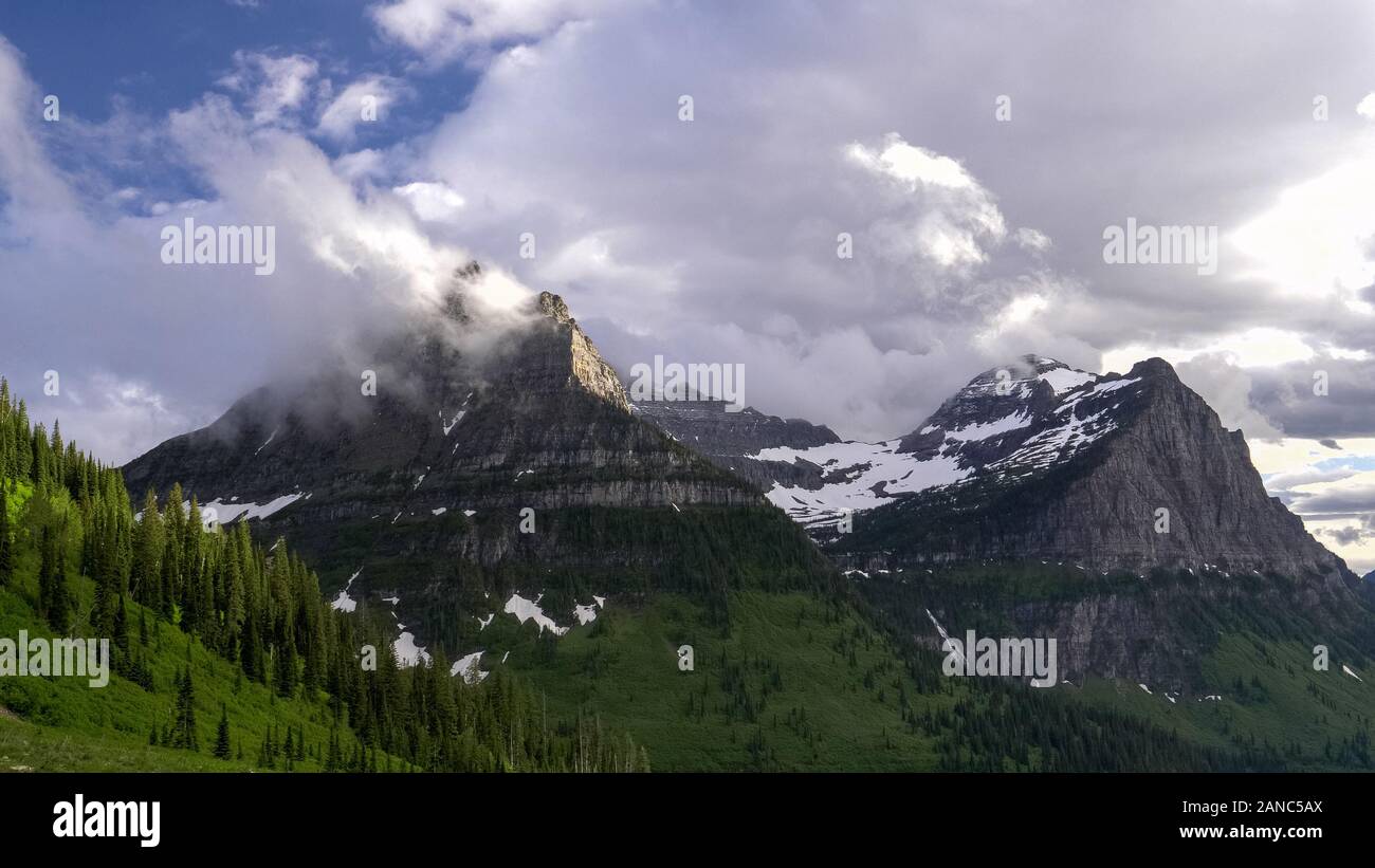 wide shot of storm clouds lifting from mt oberlin in glacier np Stock ...