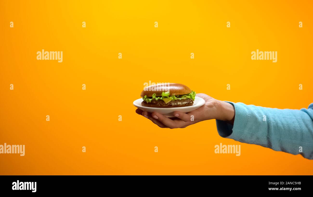 Female hand showing cheeseburger, inviting customers to fast food ...