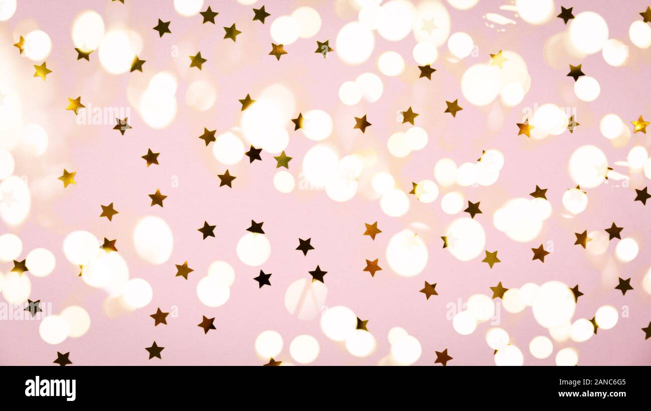 Golden star sprinkles on pink. Festive holiday background. Celebration ...