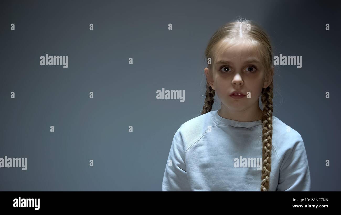 Sad female child looking at camera, bullying and family violence ...