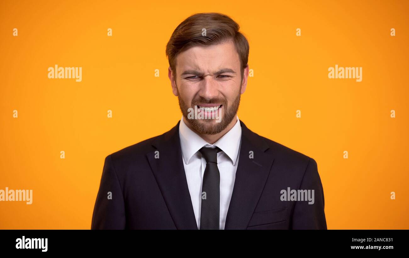 Man in suit grimacing in pain, feeling strong head or stomachache ...