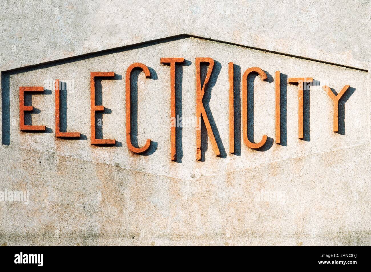 Old fashioned Electricity sign with raised letters on textured wall ...
